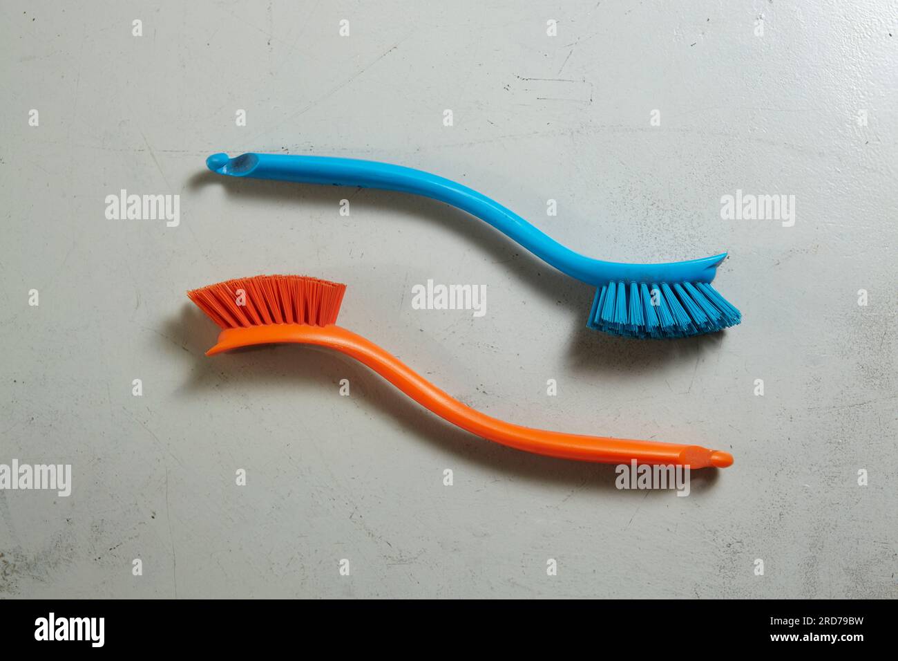 Blue and orange plastic brushes on the floor Stock Photo - Alamy