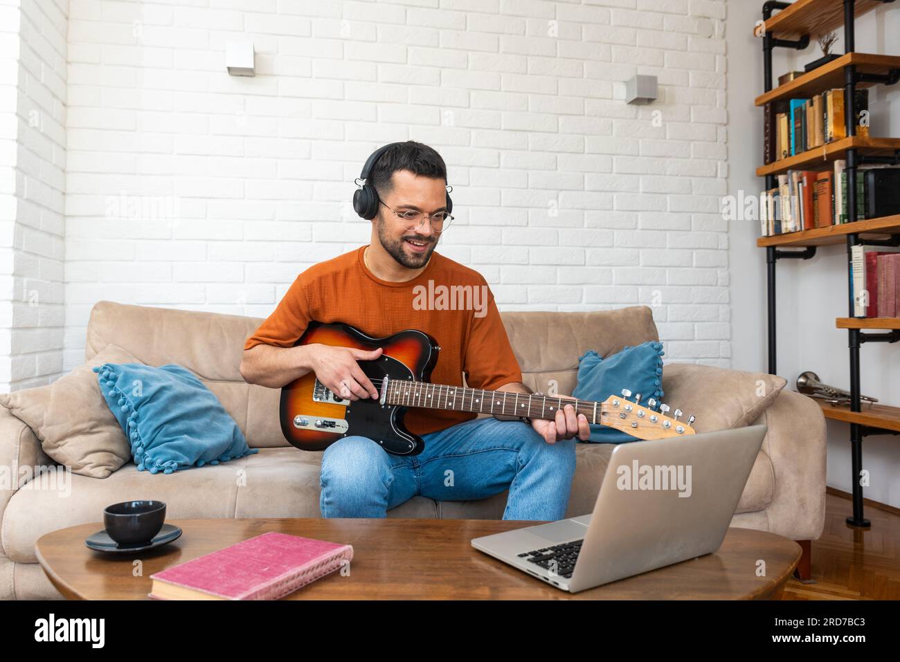 Young man music teacher giving guitar lessons to students online on ...