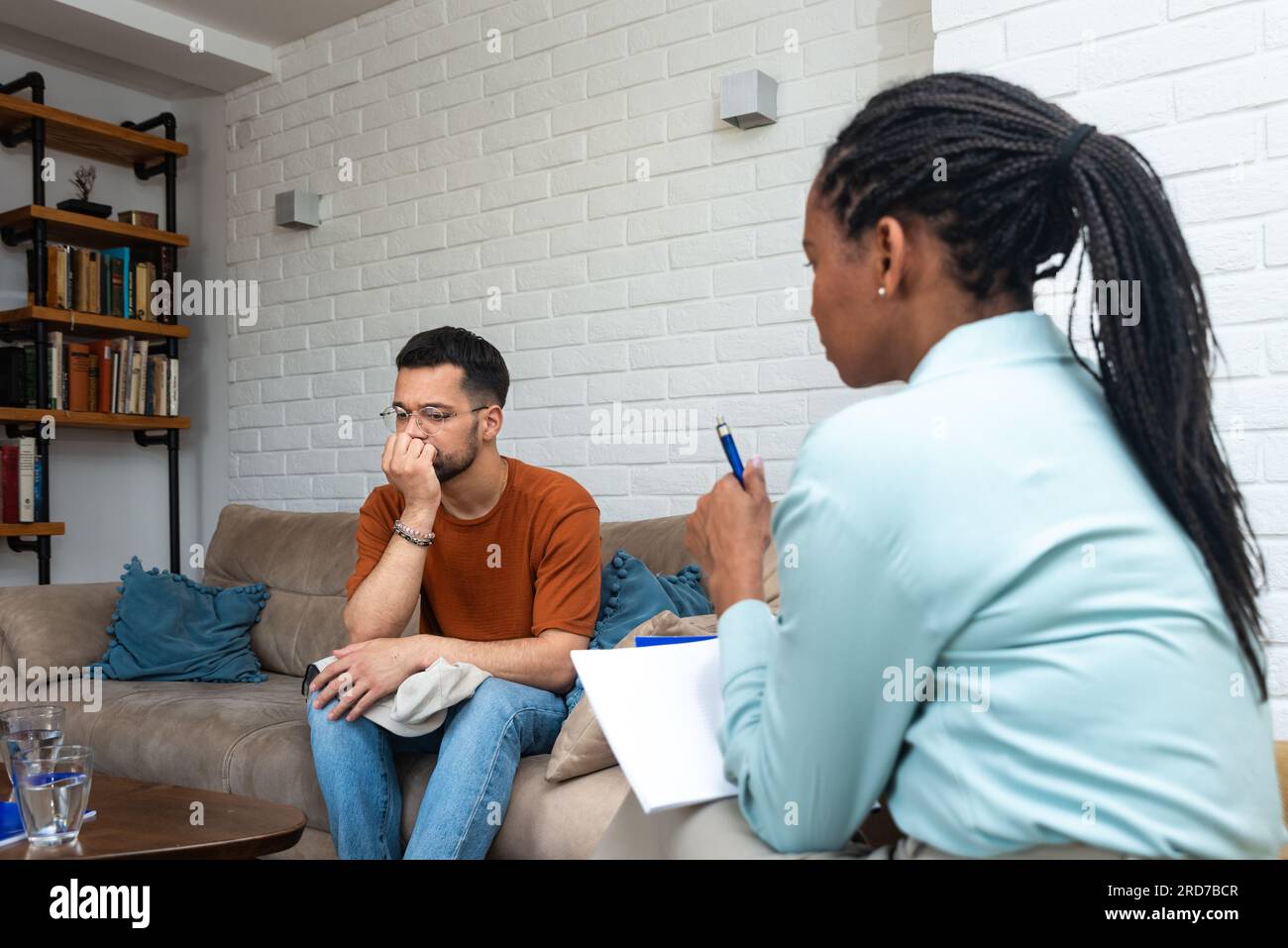 Young depressed man crying talking to mental health counselor during a ...