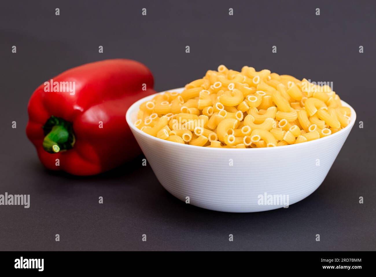 Uncooked Chifferi Rigati Pasta in White Cup and Red Bell Pepper on ...