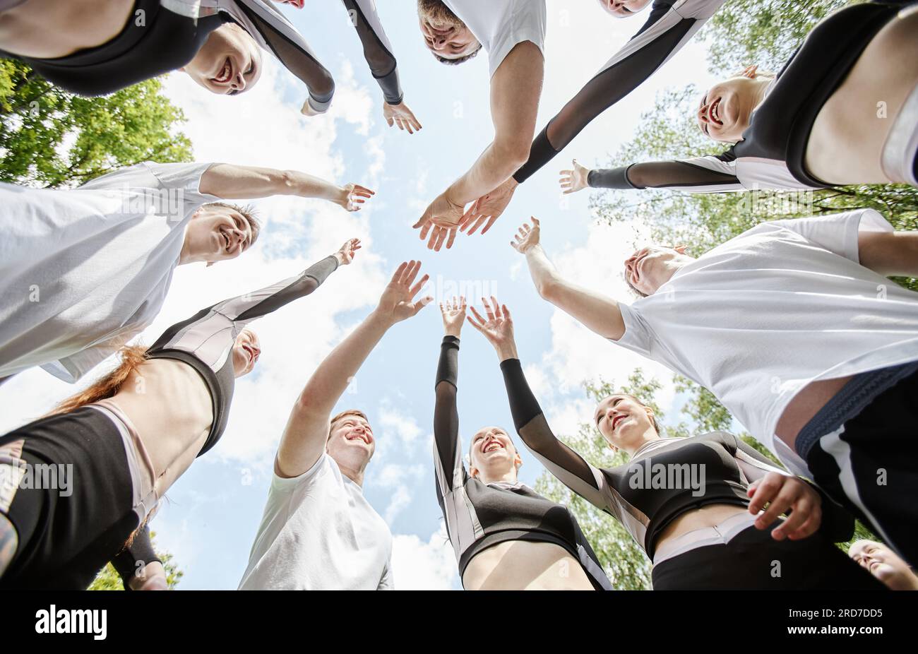 Low angle view of team of cheerleaders raising their hands up and ...