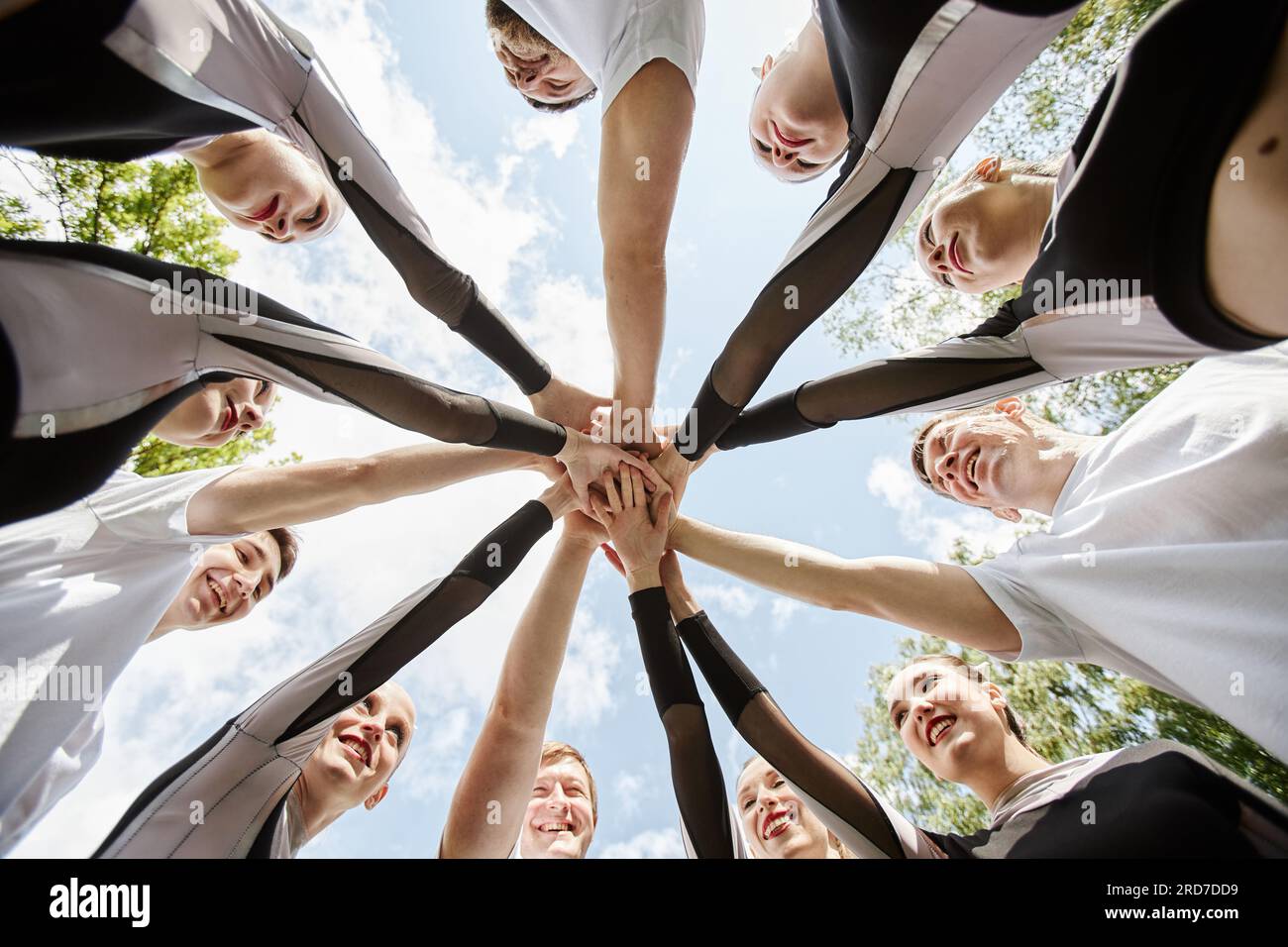 Low angle view of cheerleading team holding hands standing in circle ...
