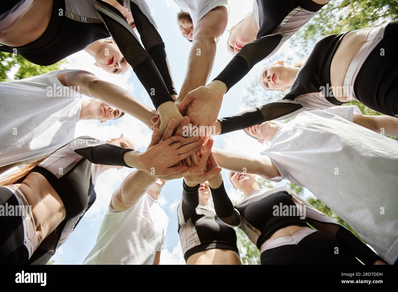 Low angle view of cheerleader team holding hands and supporting each ...