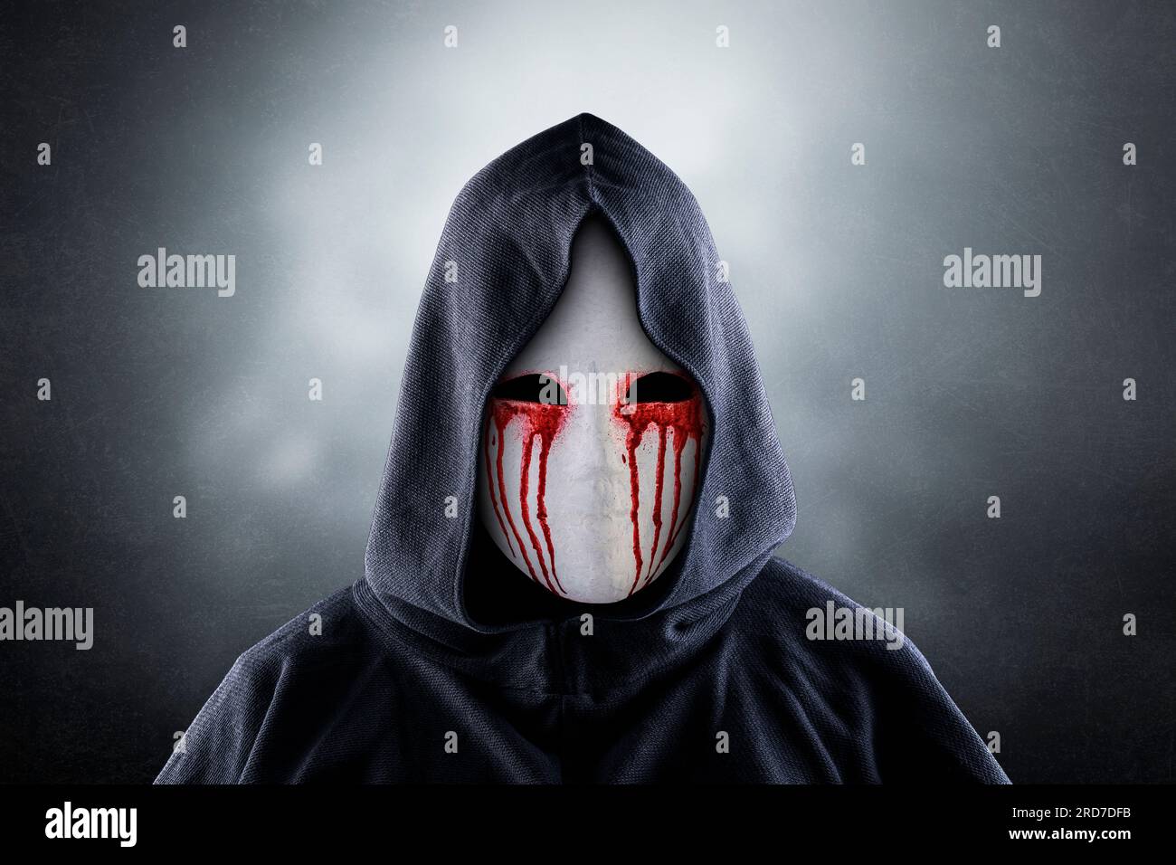 Spooky figure in blood with hooded cape over dark misty background ...