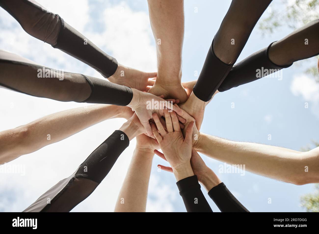 Low angle view of people from cheerleader team holding hands and ...