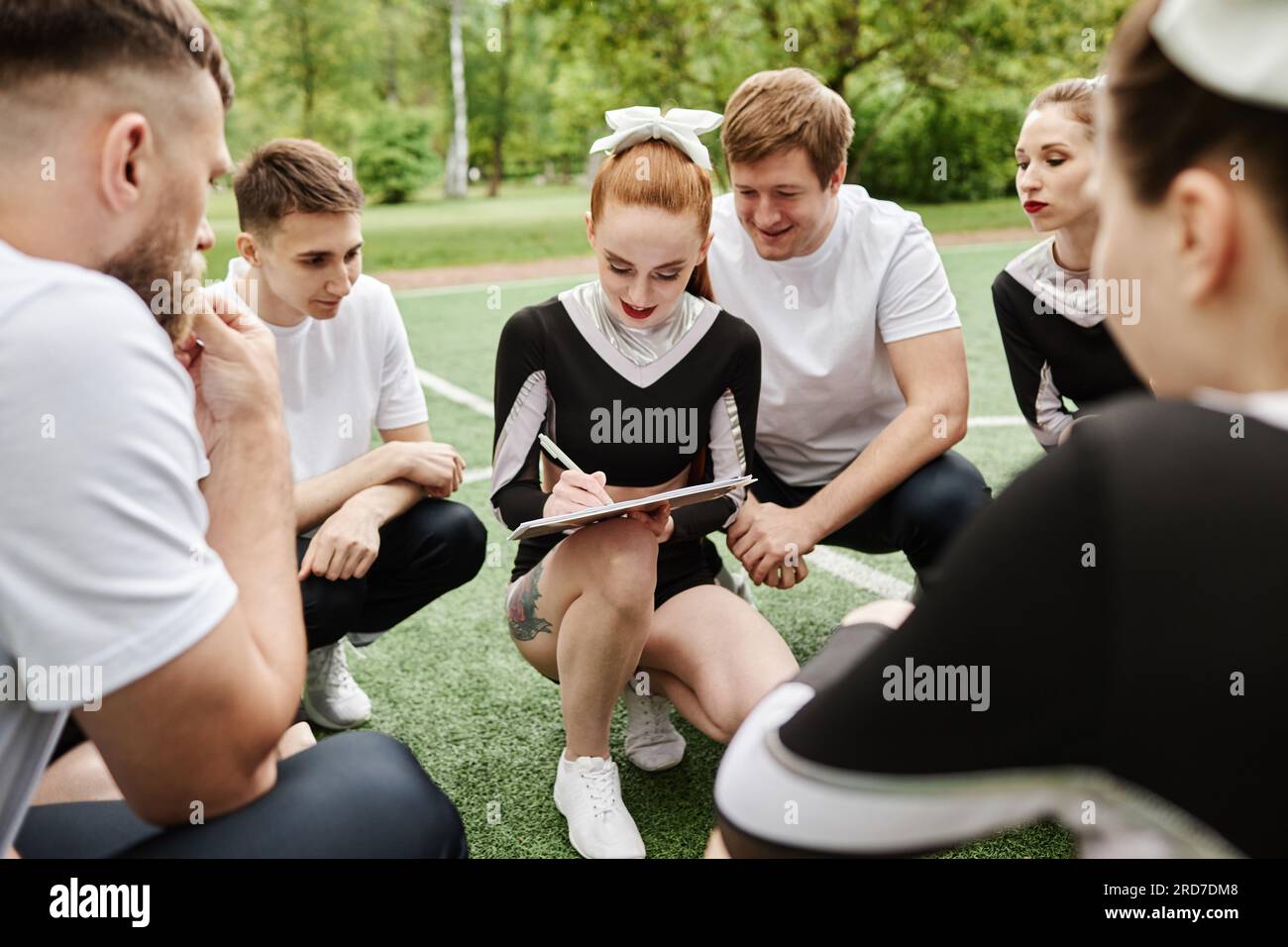 Girl from cheerleader team developing plan of performance making notes ...