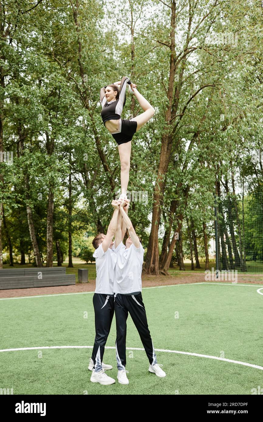 Vertical image of teenagers from cheerleading team doing trick during ...