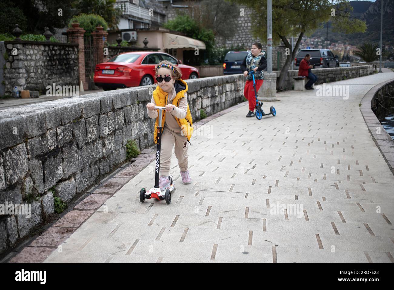 Montenegro, Apr 17, 2023: Little girl riding a kick scooter down the ...