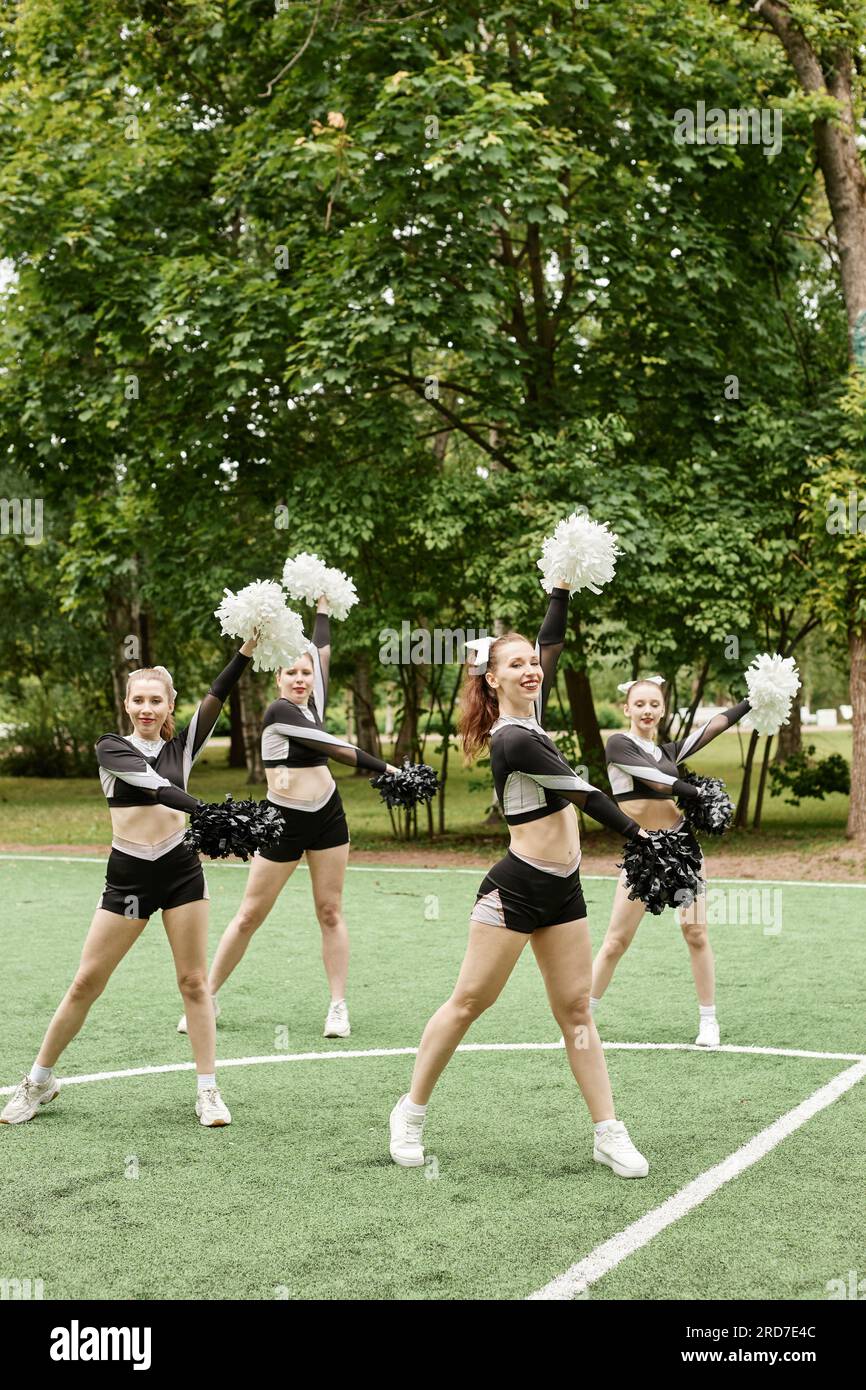 Vertical image of beautiful girls from cheerleading team dancing with ...