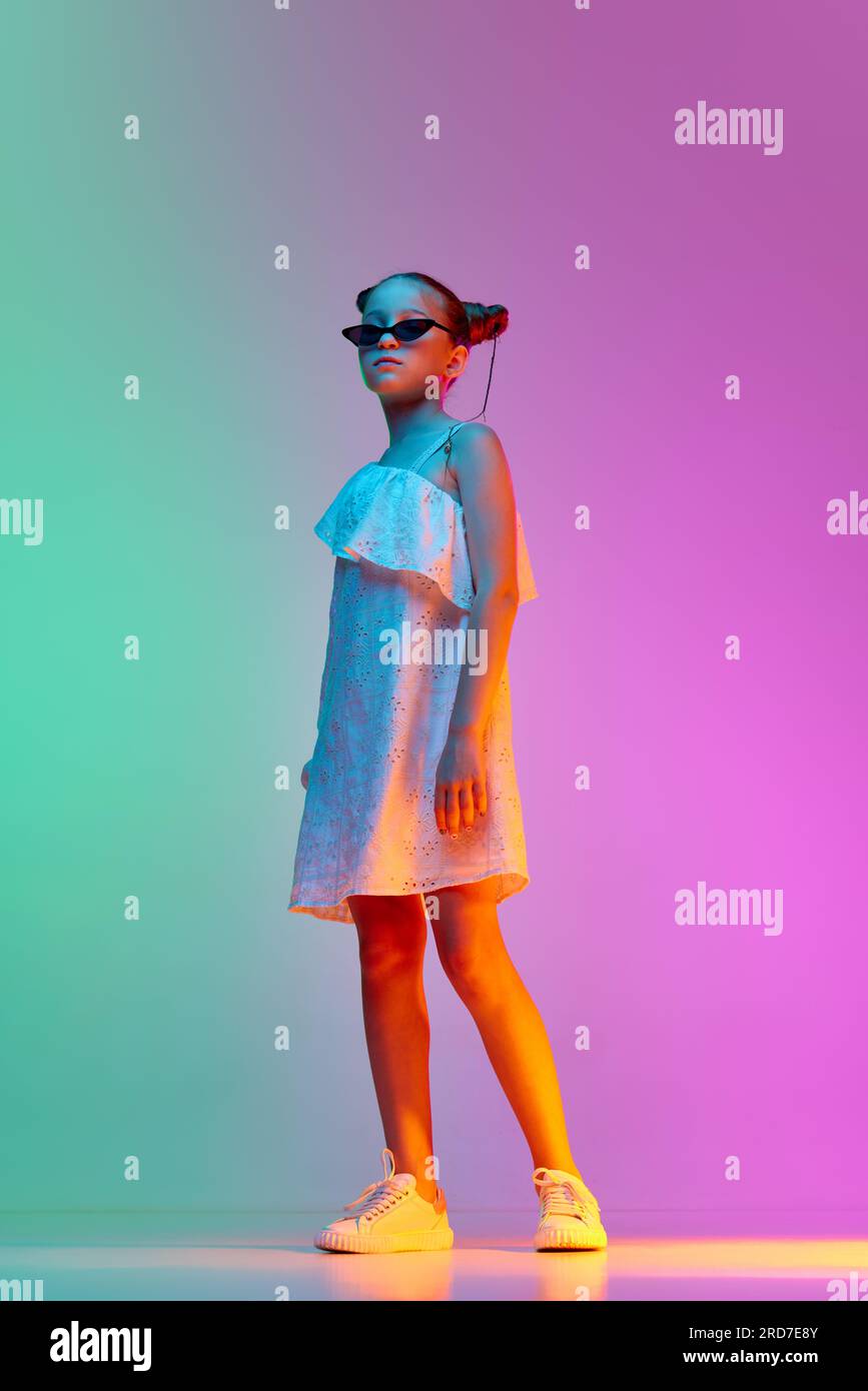 Fashionable little girl, child wearing sunglasses posing over neon ...