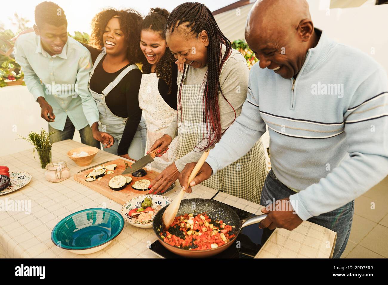 Happy african family cooking outdoor at home rooftop terrace during ...