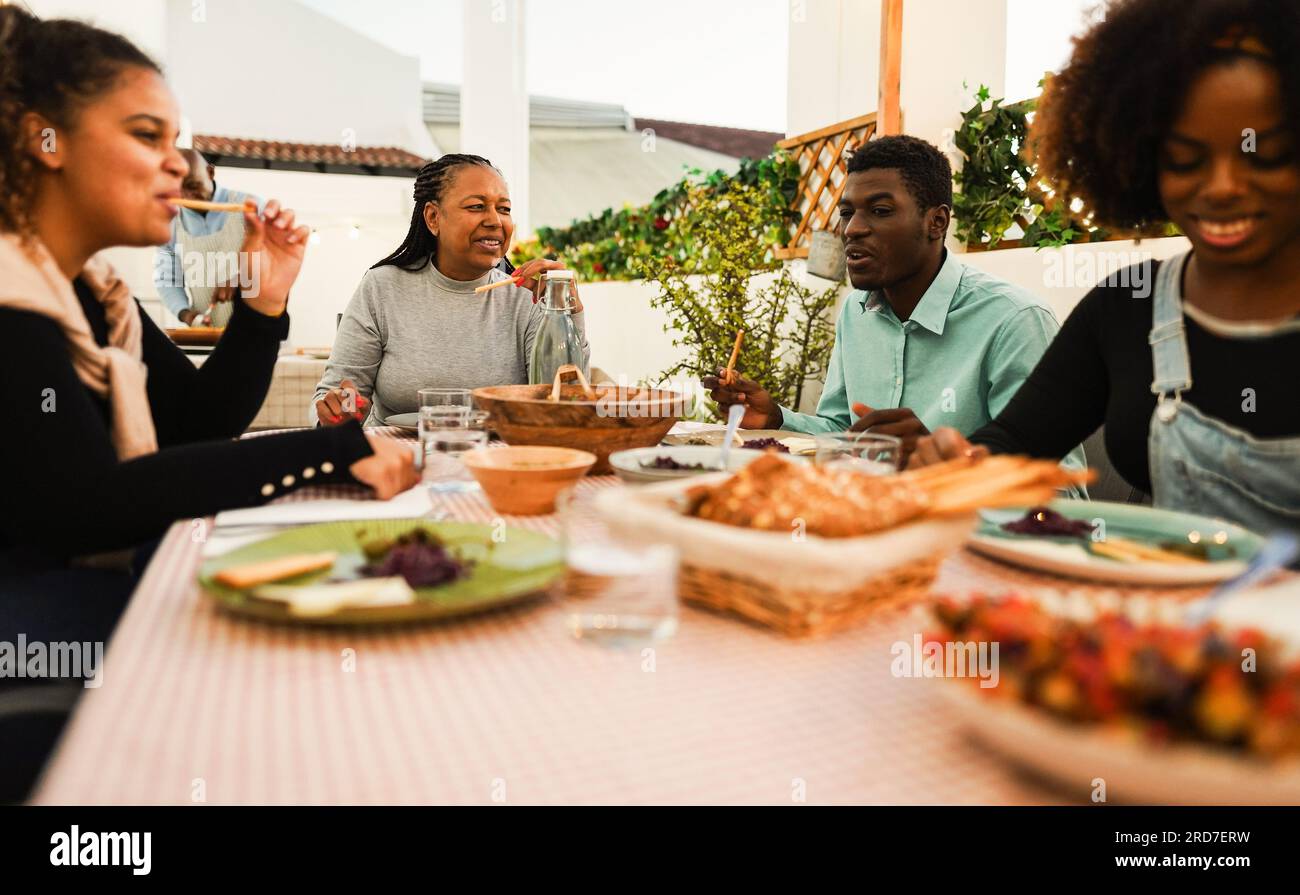 Happy african family having dinner at home rooftop terrace outdoor ...