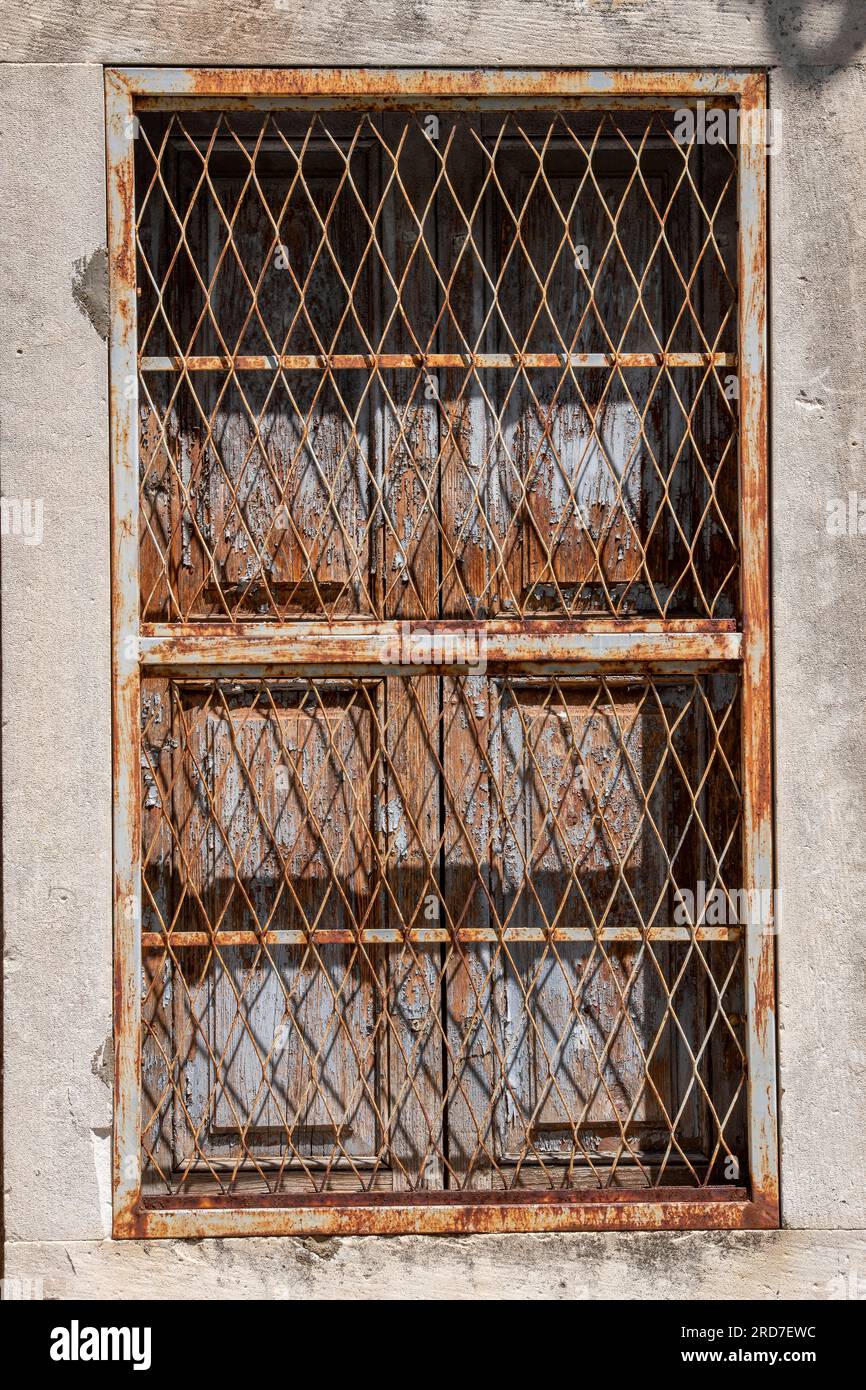 rusty old metal grille over a window on an old greek building. security ...