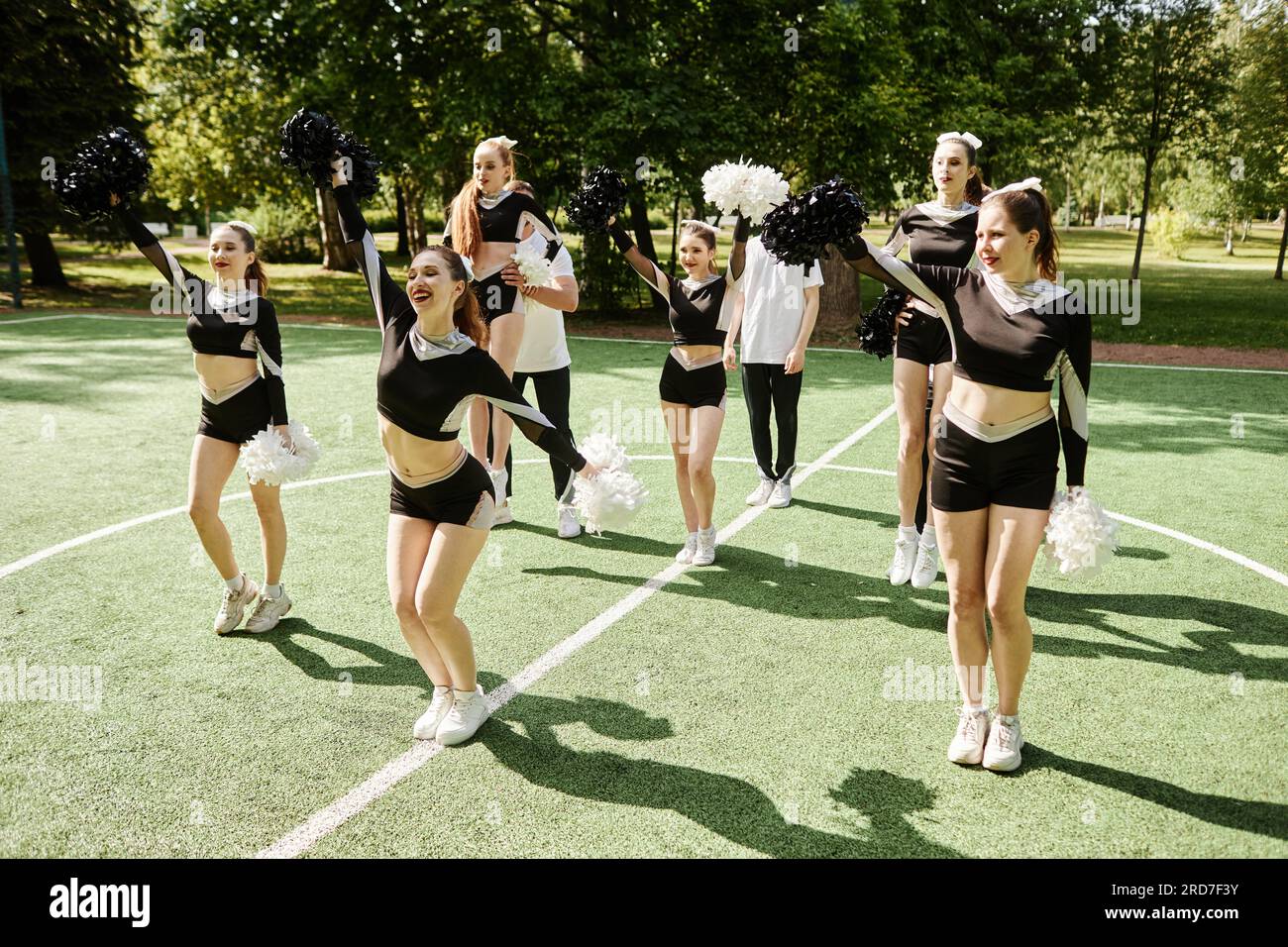 Group of cheerleading girls dancing with pompom at competition outdoors ...
