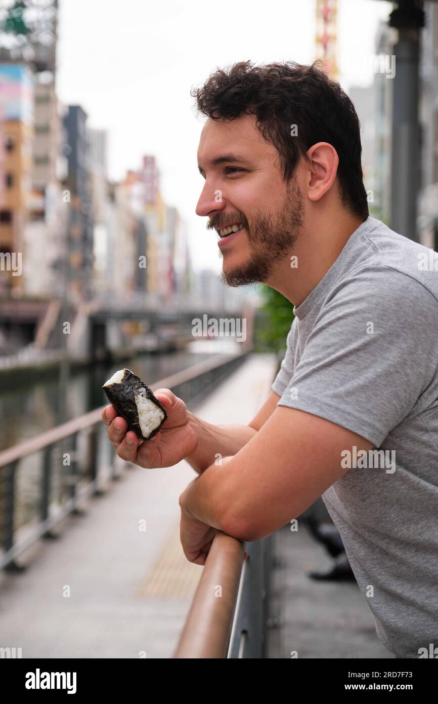 Tourist eating onigiri street hi-res stock photography and images - Alamy
