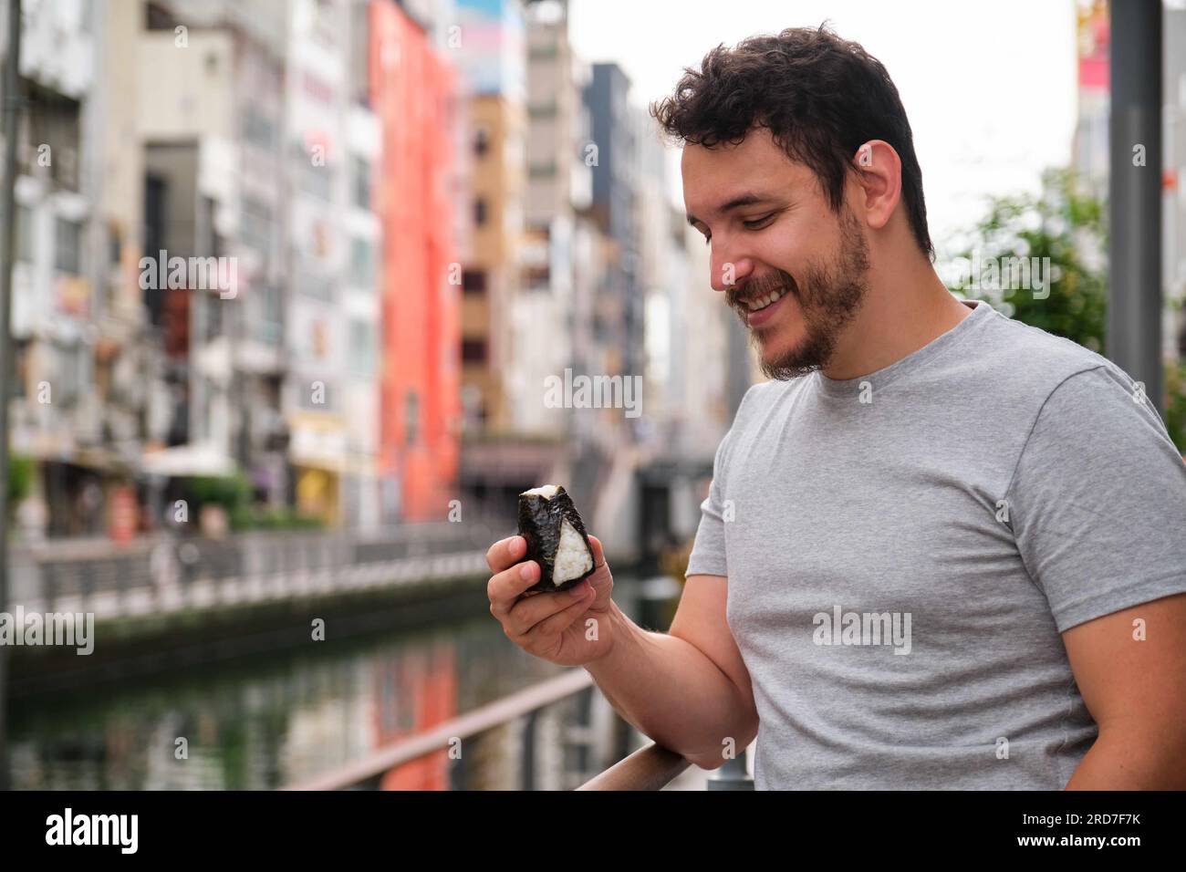 Tourist eating onigiri at street Stock Photo - Alamy