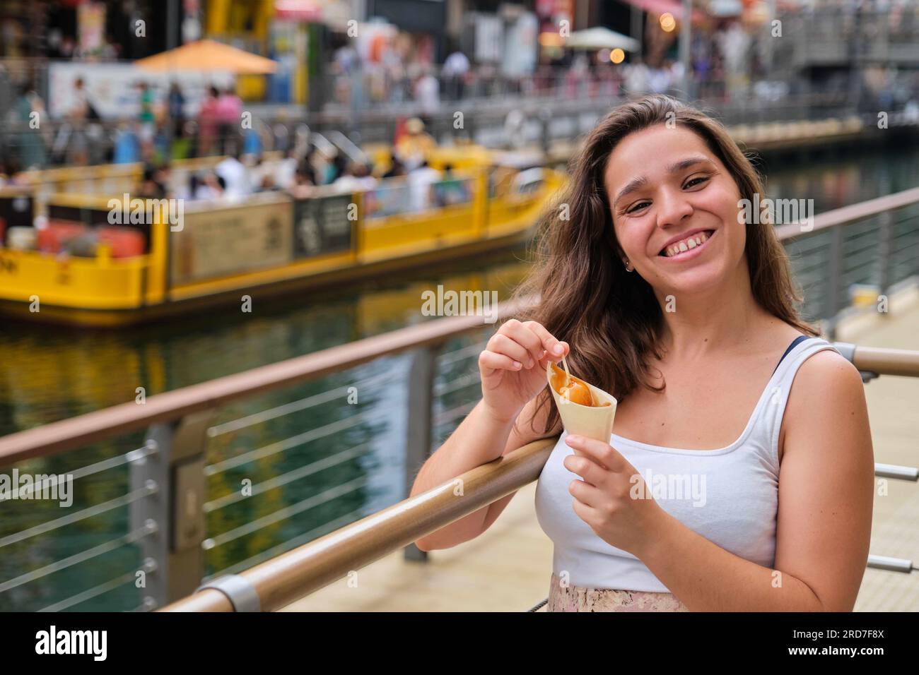 Tourist eating mitarashi dango and looking at camera at street Stock ...