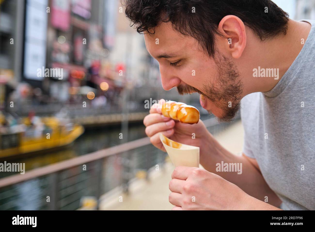 Tourist eating mitarashi dango at street Stock Photo - Alamy