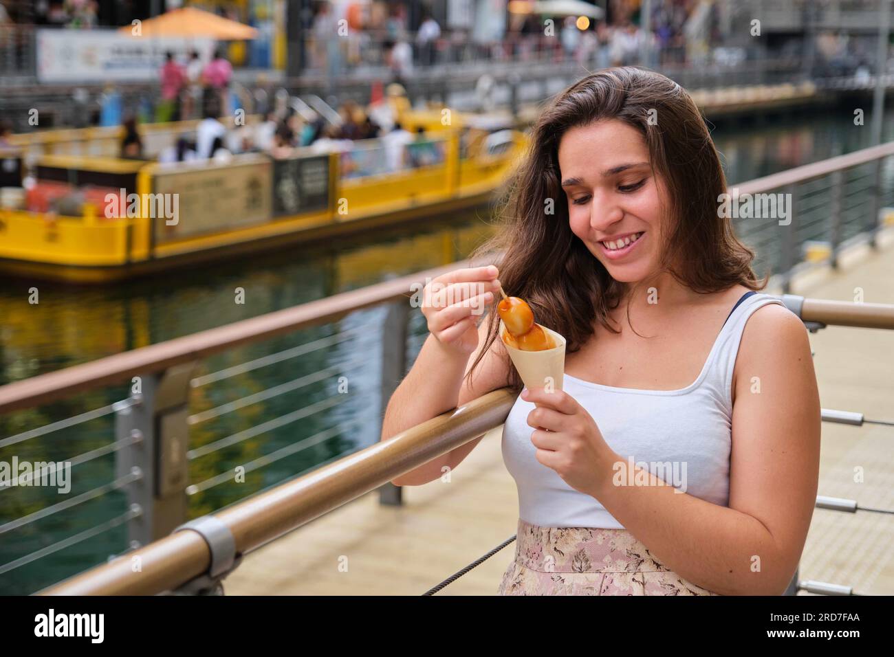 Tourist eating mitarashi dango at street Stock Photo - Alamy