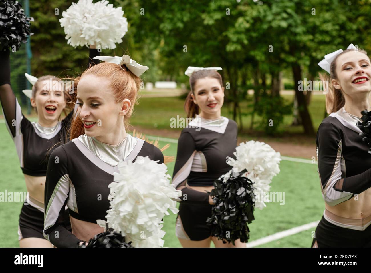 Group of cheerleading girls dancing outdoors at sport competition Stock ...