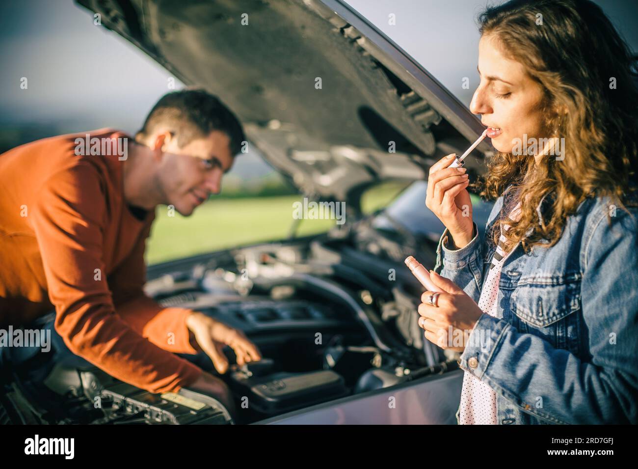 Funny scenario. A young couples car breakdown. The young man is trying ...