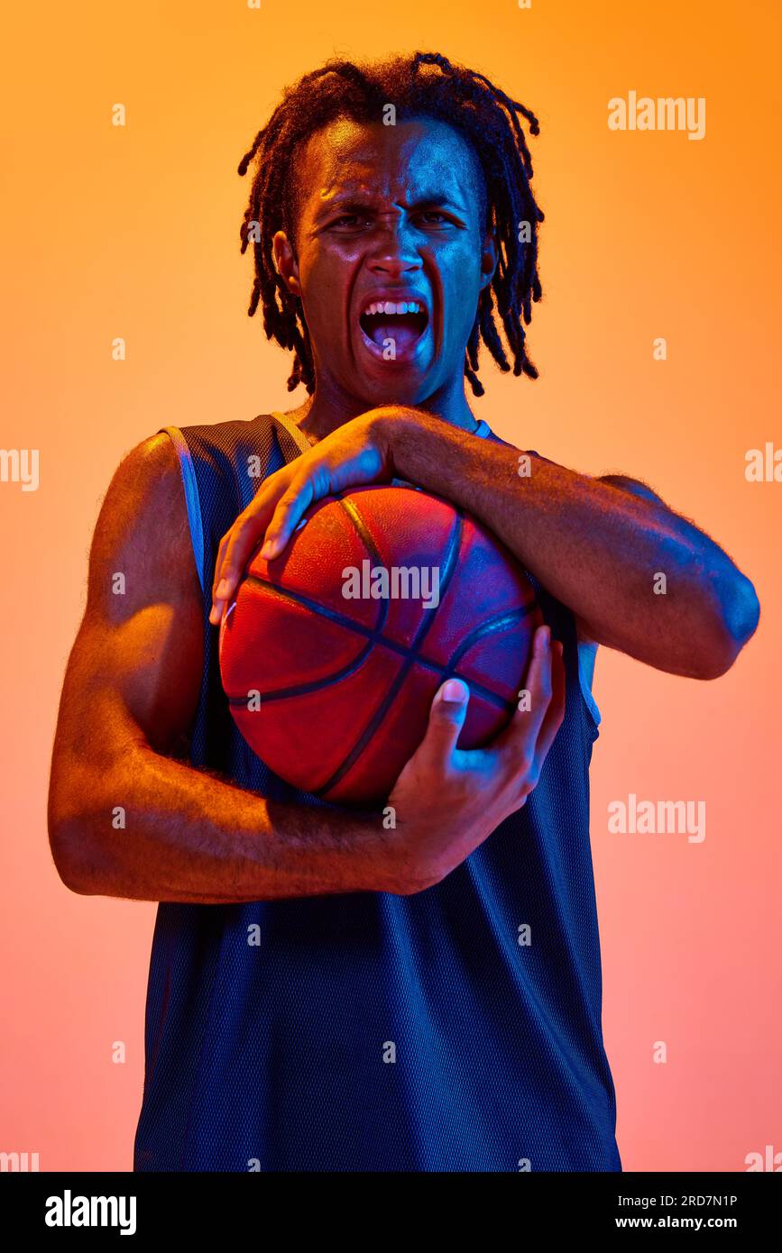 Portrait of young man with dreads, basketball player posing in uniform ...