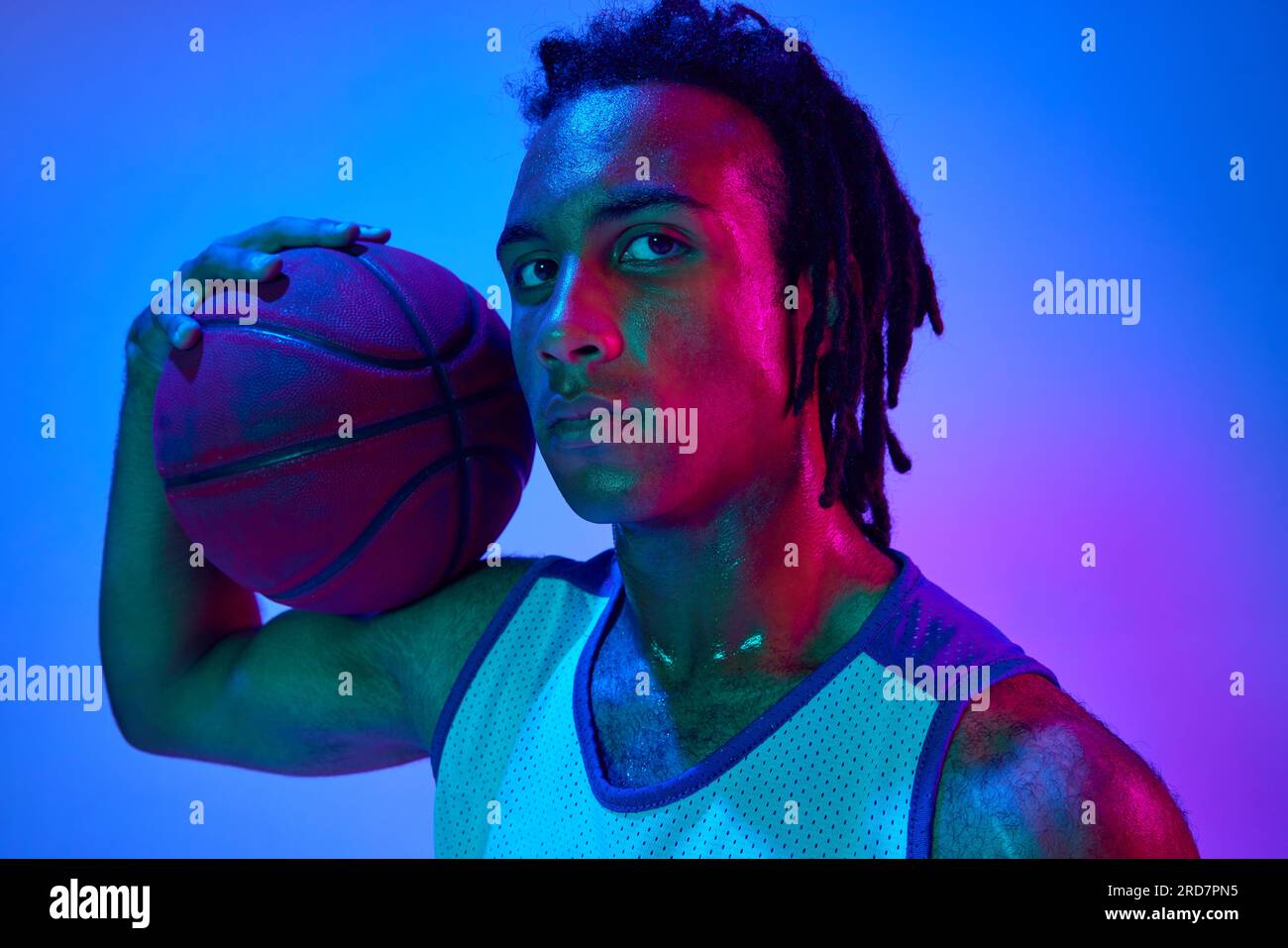 Portrait of handsome young man, basketball player posing with ball ...
