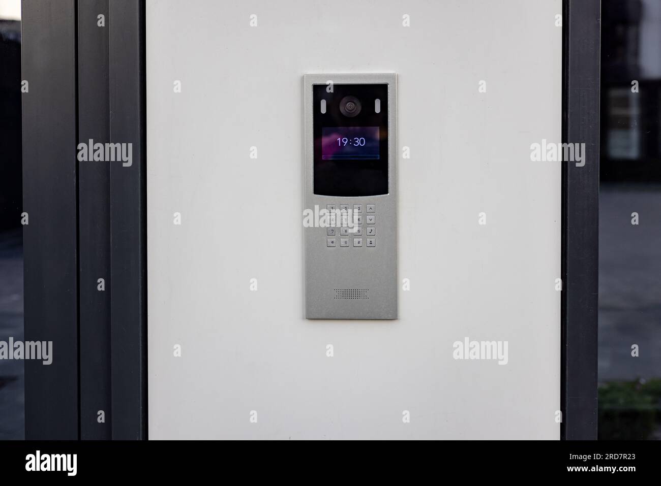 Doorbell with video camera and microphone, on the white wall of an ...