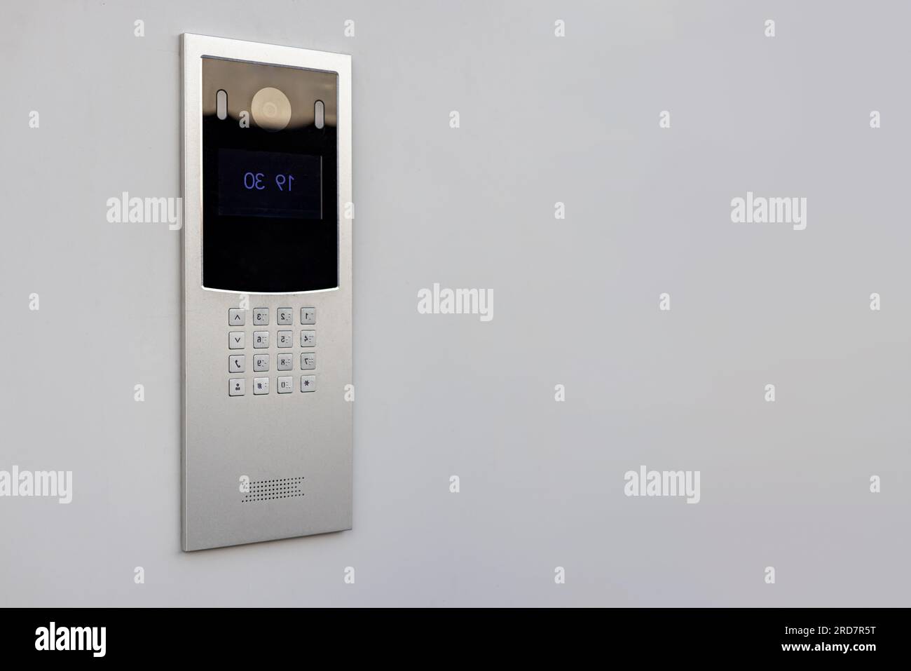 Doorbell with video camera and microphone, on the white wall of an ...