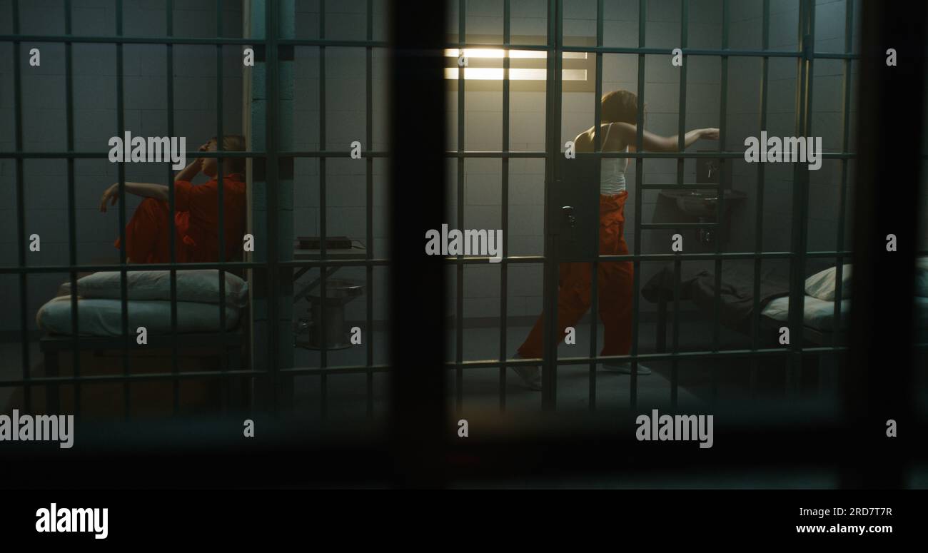 One female prisoner in orange uniform lies on the bed, another boxing ...