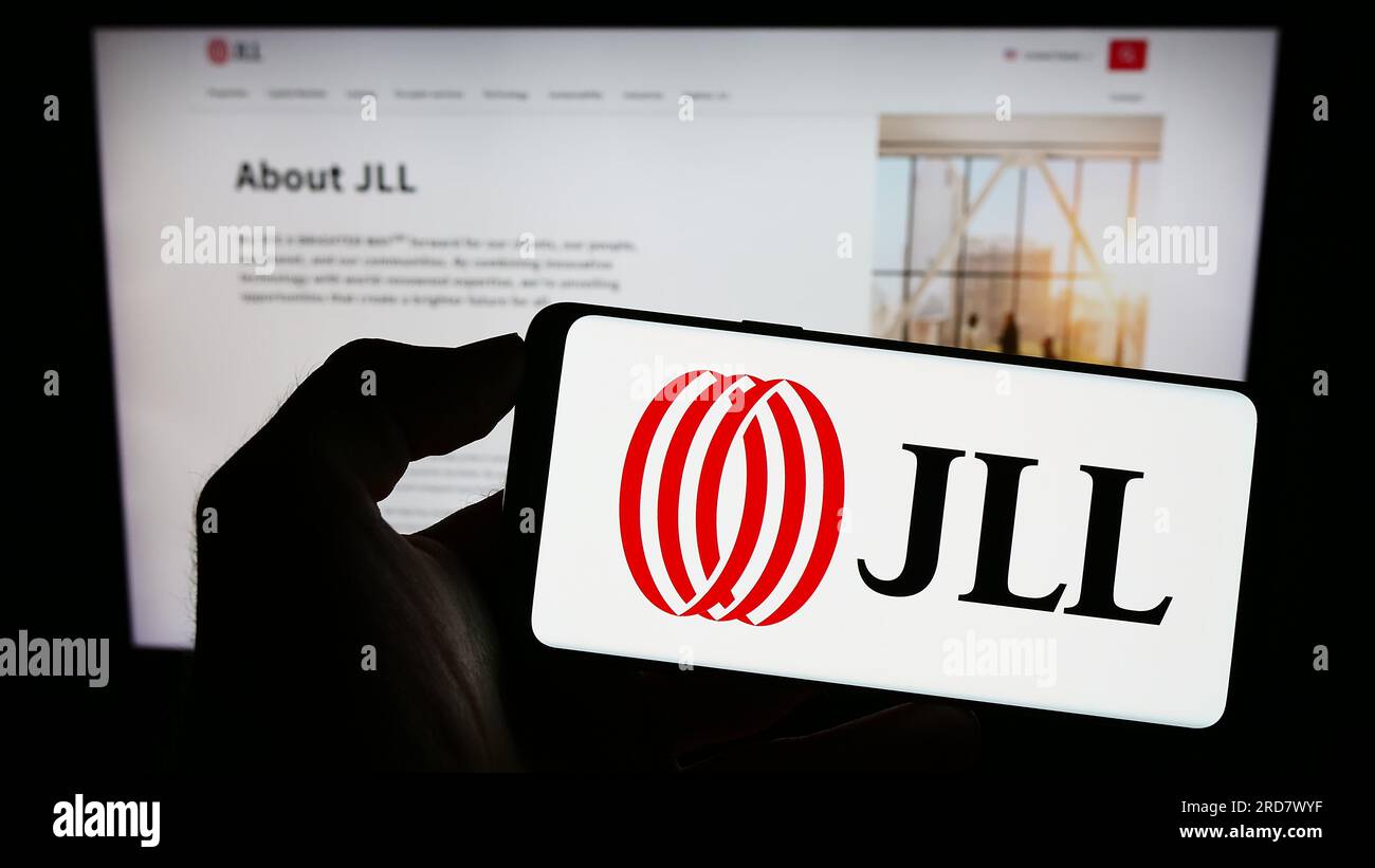 Person holding smartphone with logo of company Jones Lang LaSalle ...