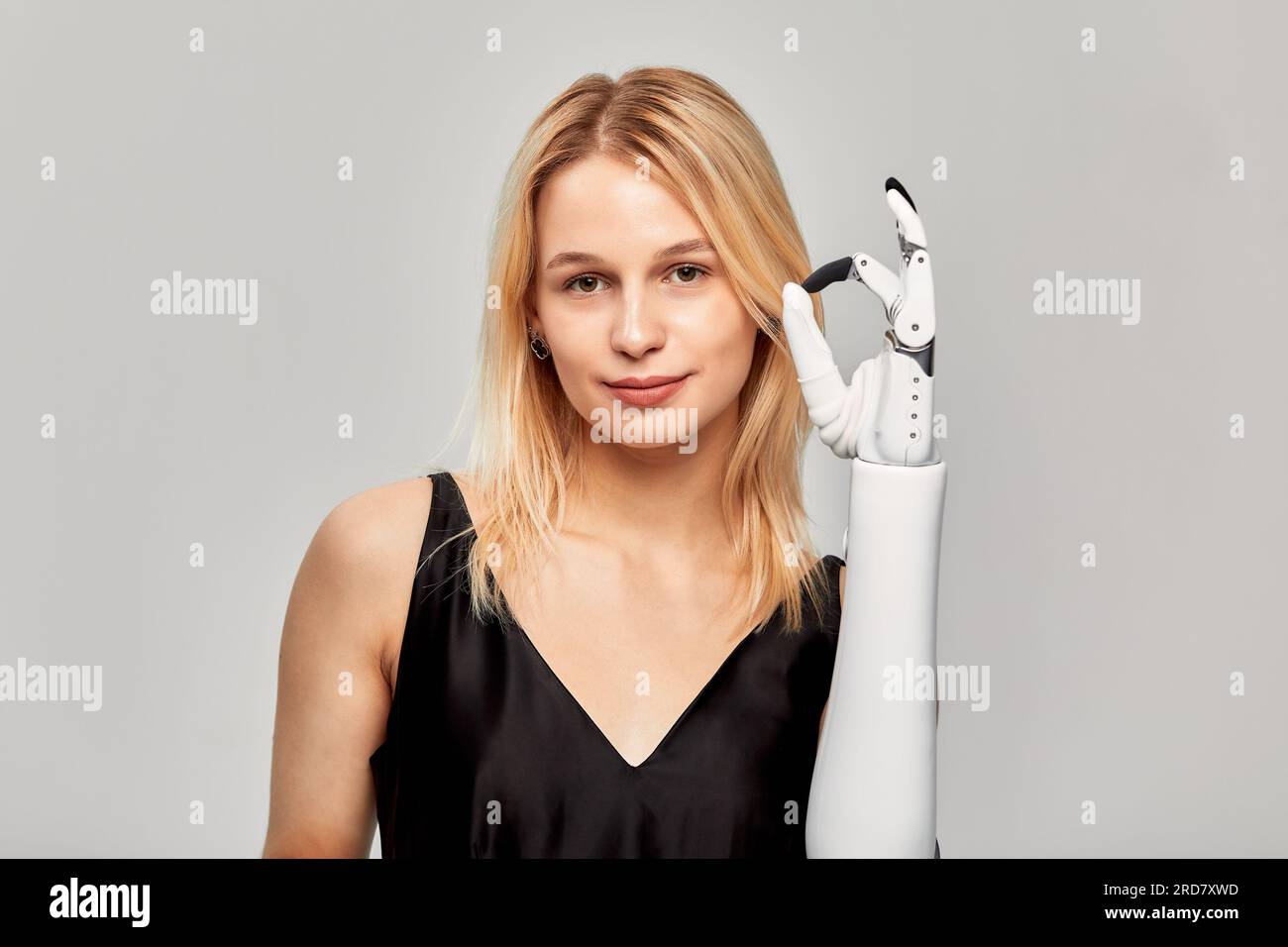 Studio portrait of beautiful young blonde girl with disability wearing ...