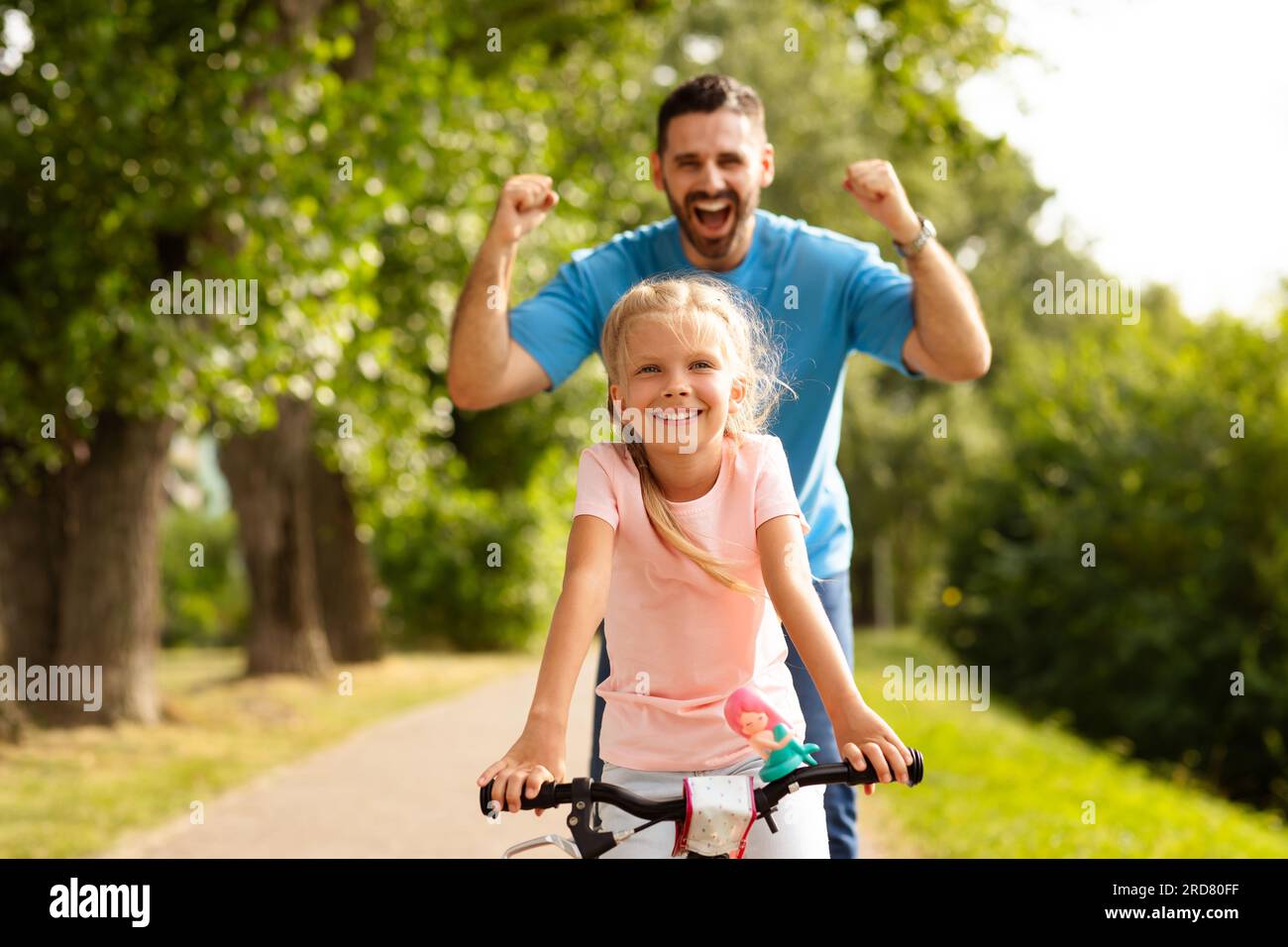 Happy girl learning to ride a bike with dad hi-res stock photography ...