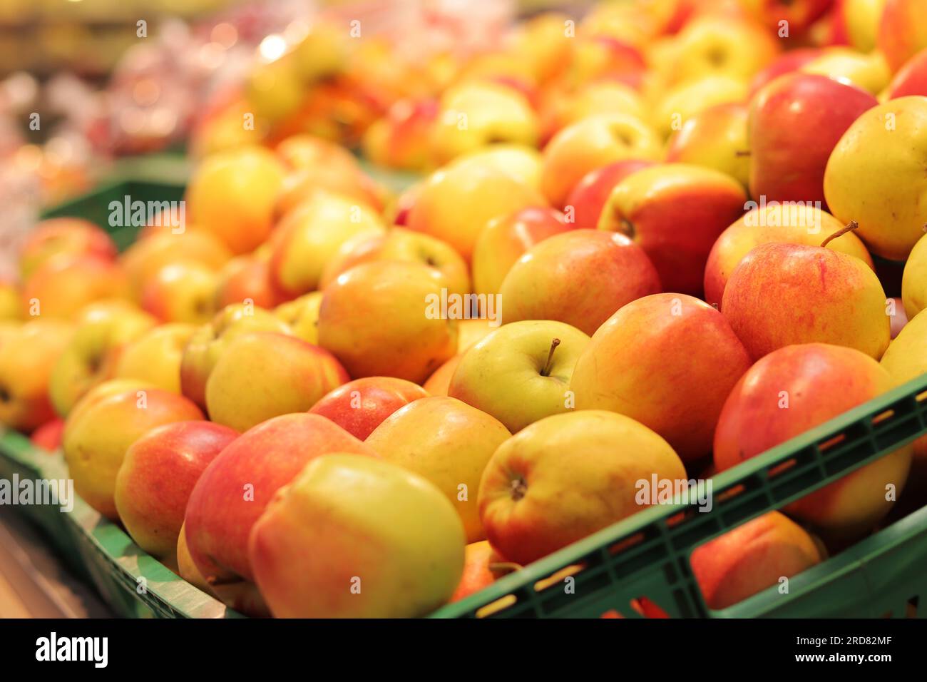 Apples in plastic boxes in a store, close-up. Ripe apples on sale, side ...
