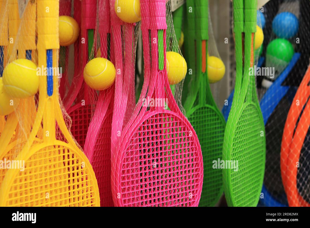 Tennis rackets in different colors in the store. Plastic tennis racket ...