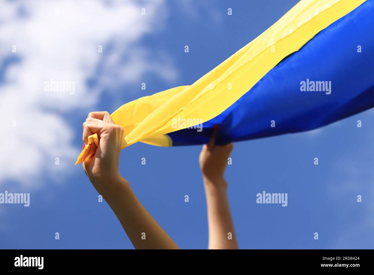 Women's hands with the Ukrainian flag against the sky. Concept: war in ...