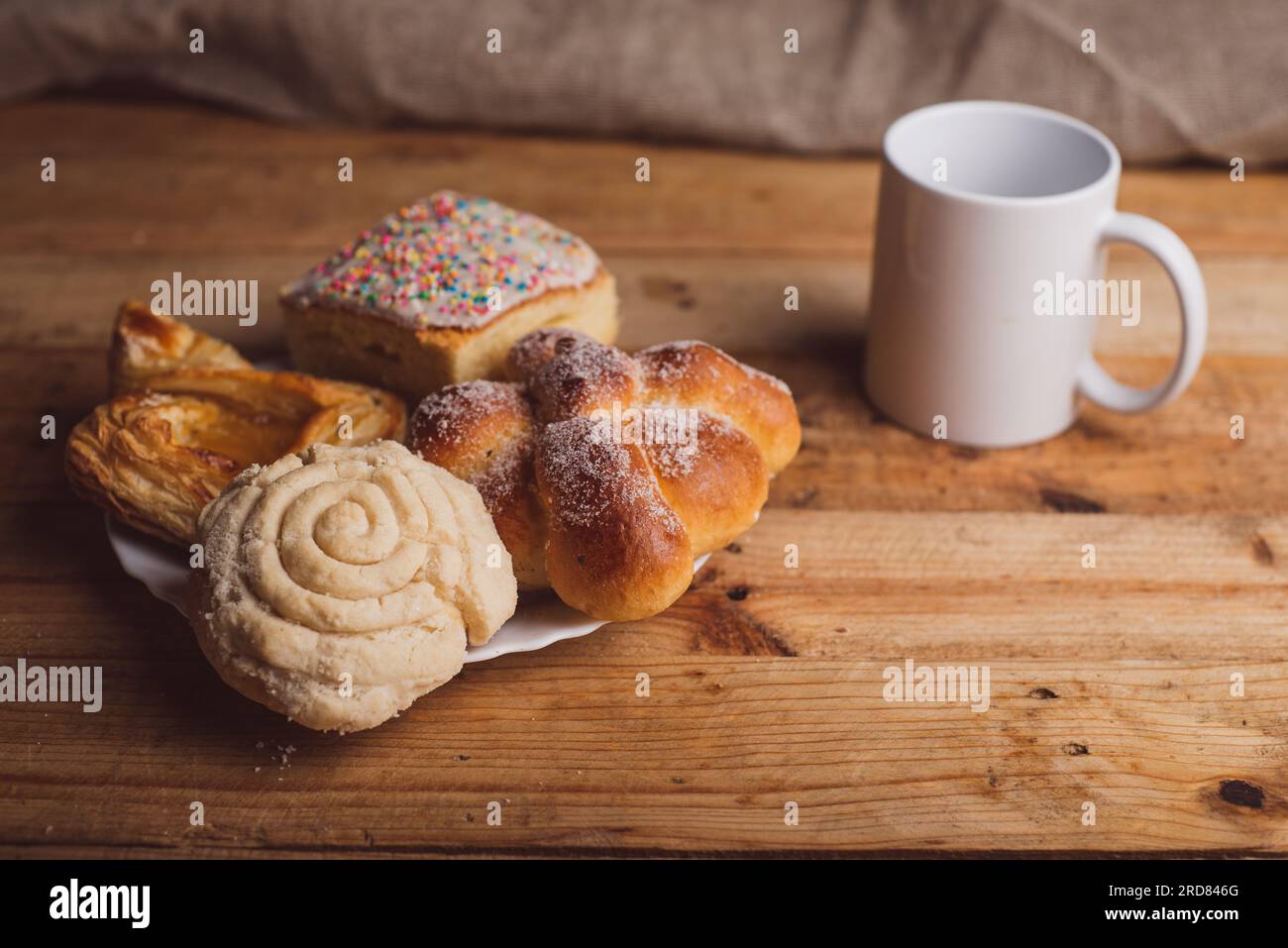 Pan de muerto, concha and other sweet breads on wooden table. Typical ...