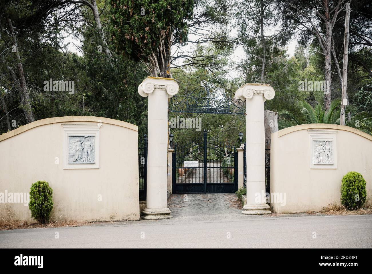 A double set of wrought iron gates mounted between classical columns ...