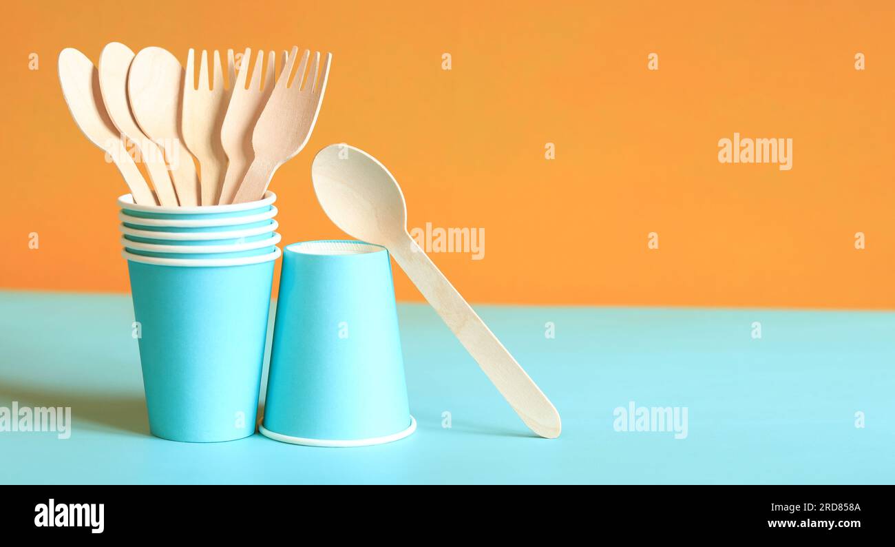 Wooden disposable forks and spoons in a blue paper cup, side view. Eco ...