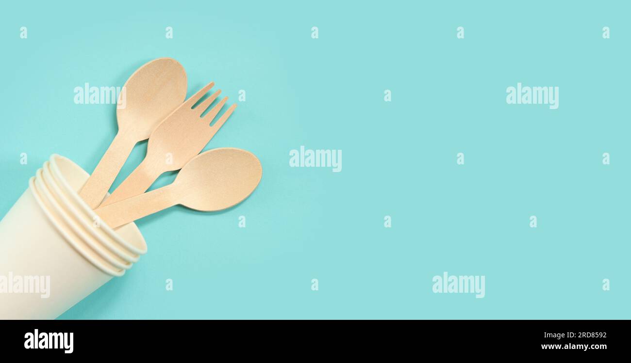 Wooden disposable forks and spoons in a paper cup, top view. Eco ...