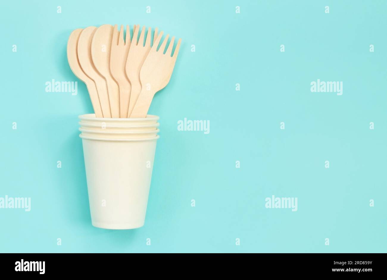 Wooden disposable forks and spoons in a paper cup, top view. Eco ...