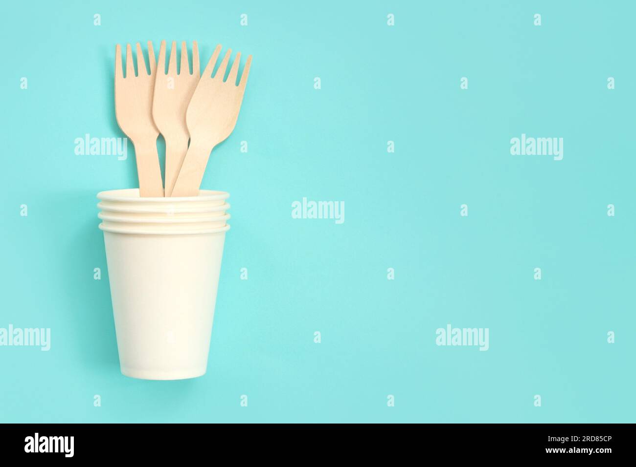 Wooden disposable forks in a white paper cup, top view. Eco friendly ...