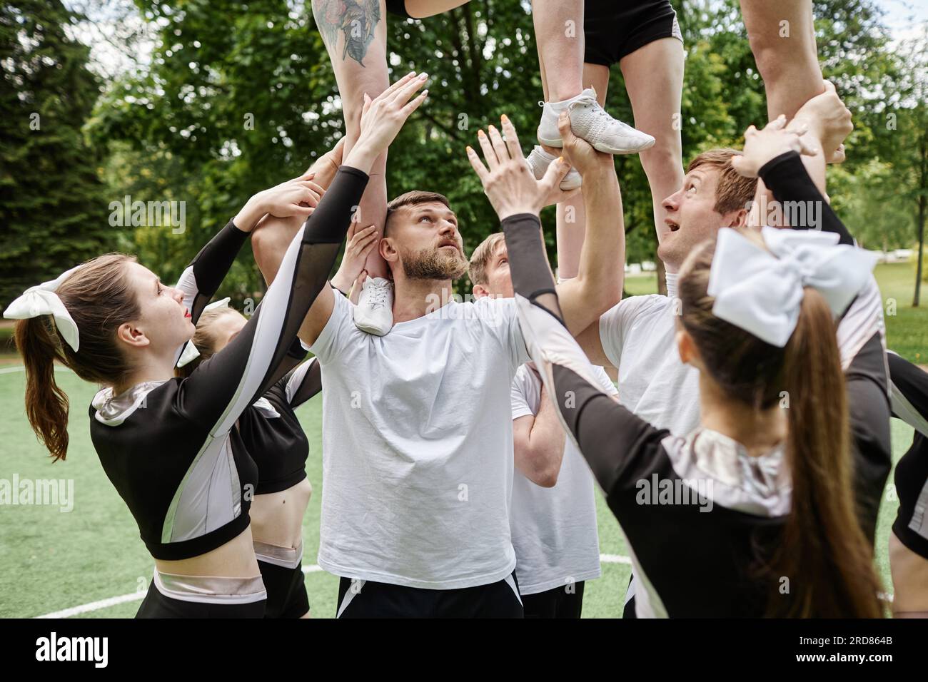 Cheerleader team training with coach outdoors before performance Stock ...