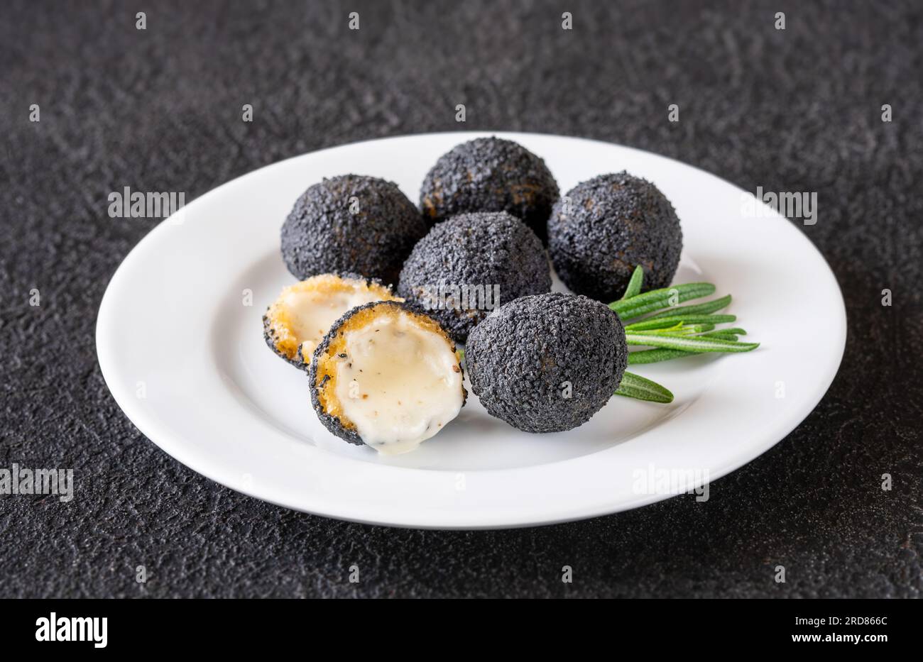 Mozzarella balls breaded with black truffle on the plate Stock Photo ...