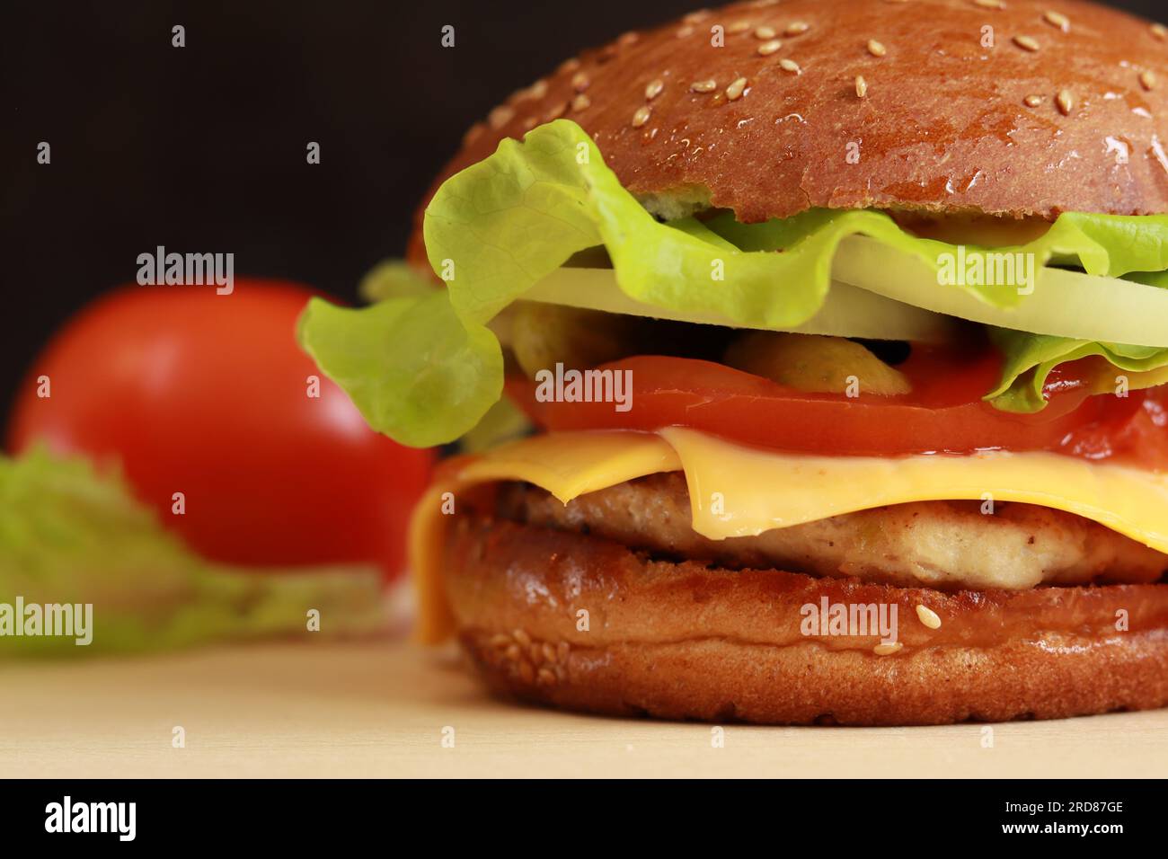 Cheeseburger with chicken cutlet close-up. Homemade burger and tomatoes ...