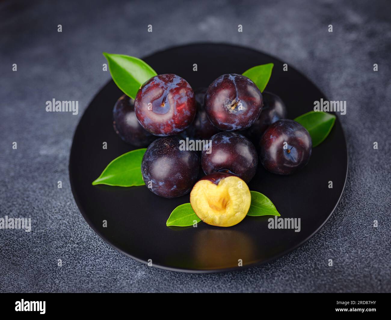 Sweet plums on dark background. Fresh blue plums with leaves. Food ...