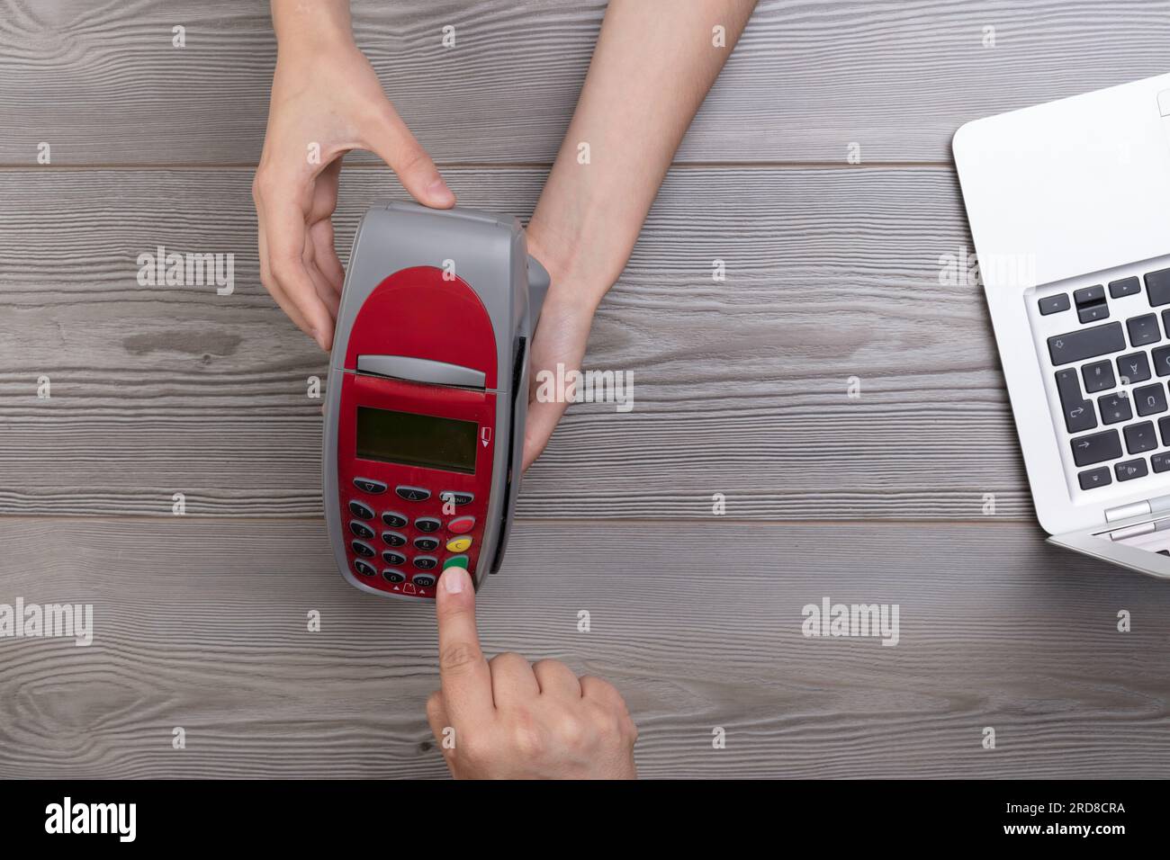 Overhead shot of merchant and client hands over a rustic counter, using ...