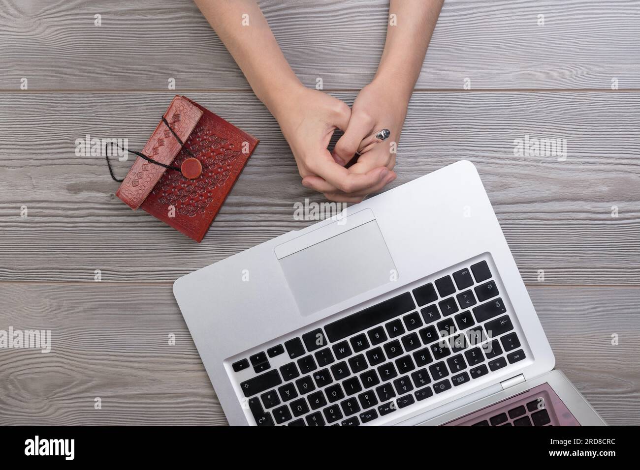 Top-down image of a young person's hands holding a pen, surrounded by a ...