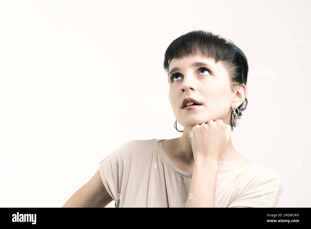 Young woman with bangs in beige top, showing exaggerated expression of ...