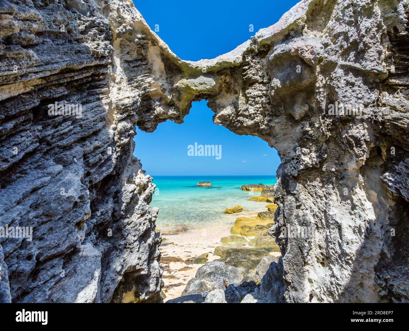 Blue and turquoise Sargasso Sea, glimpsed through an arch in the island ...